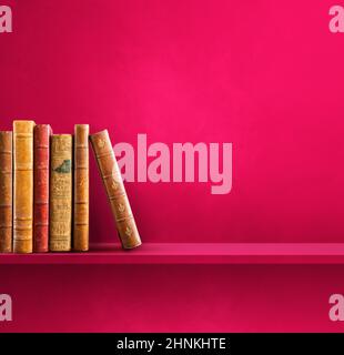 Row of old books on pink shelf. Horizontal background scene Stock Photo ...