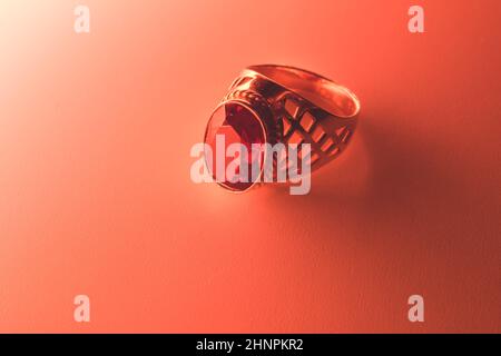 Golden ring with ruby under red light background Stock Photo - Alamy