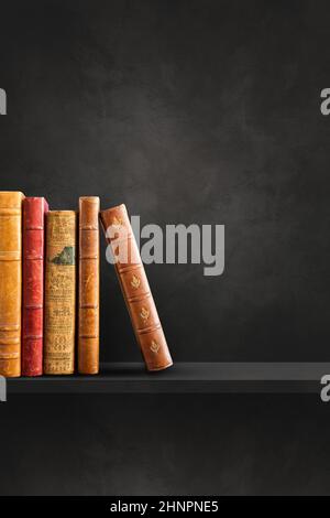 Row of old books on black shelf. Horizontal background scene Stock ...