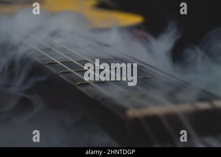 Acoustic guitar in smoke close up. musical instrument. strings on the ...