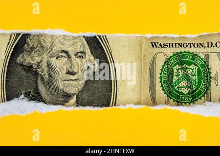 US currency macro peeking through torn yellow paper Stock Photo - Alamy
