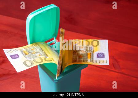 Euro banknote in a garbage can as a symbol for garbage fees, waste of ...