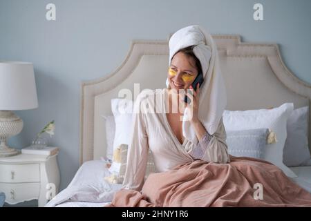 Cute lady with eyes patches at home writing notes on a diary while ...