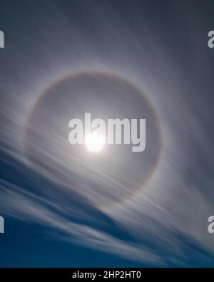 Solar halo phenomena and rainbow produced by light against the blue sky ...
