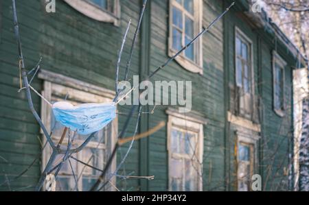 Abandoned used medicine mask tied to the tree branches Stock Photo - Alamy
