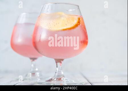 Pink vodka lemonade cocktail garnished with lemon wedge Stock Photo - Alamy