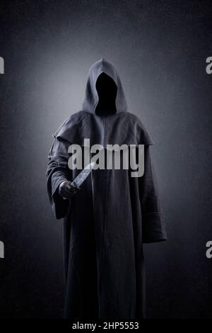 Hooded man with old knife in the dark Stock Photo - Alamy