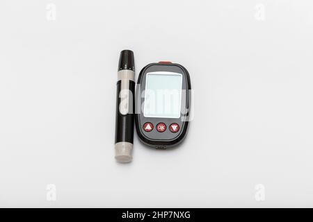 Electronic glucometer, lancet pen and test strip isolated on white ...