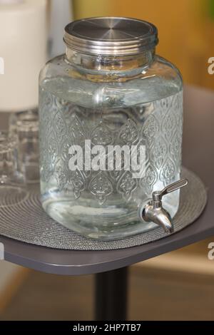 Refreshing drink dispenser with glass jar container full of yellow ...
