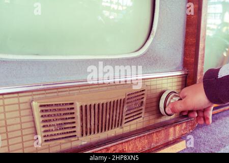 The hand changes channels on the retro old TV. Turning on of the ...