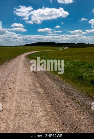 a winding mud and stone track disappearing in to distant horizon ...