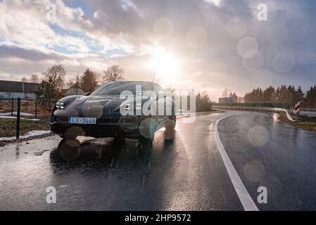 Porsche Taycan Gran Turismo Electric model driving down the road Stock ...