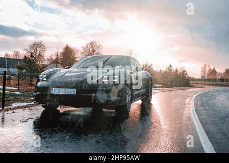 Porsche Taycan Gran Turismo Electric model driving down the road Stock ...