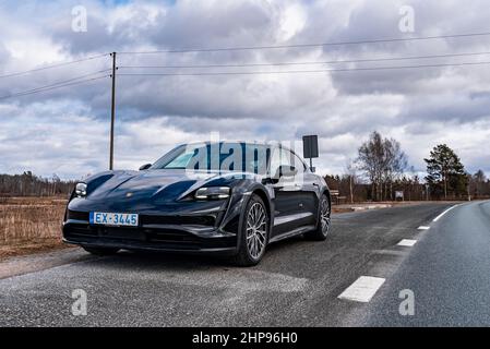 Porsche Taycan Gran Turismo Electric model driving down the road Stock ...