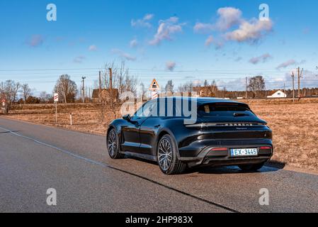 Porsche Taycan Gran Turismo Electric model driving down the road Stock ...