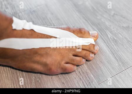 Man with foot wrapped in medical bandage on white background, closeup ...