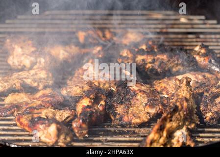 Grilling traditional Jamaican spicy jerk chicken with over wood fire ...