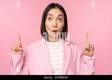 Enthusiastic saleswoman, business woman pointing finger at mobile phone ...