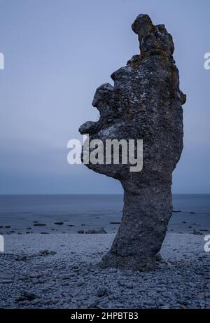 A tall rock formation resembling a face on a beach at Langhammers ...