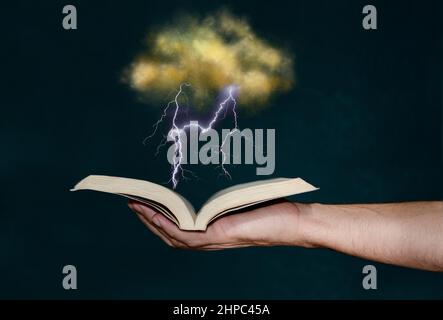 Man holding magic book with hand Stock Photo - Alamy
