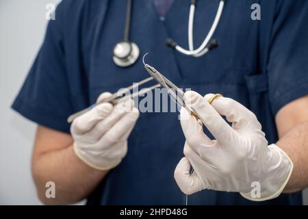 Forceps in doctor hand with disposable glove on white background ...