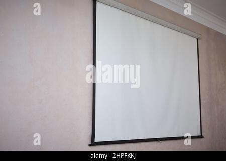 Large projector screen on the wall Stock Photo - Alamy