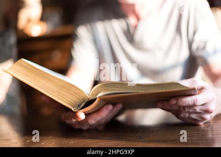 Man reading the Bible in dim light Stock Photo - Alamy