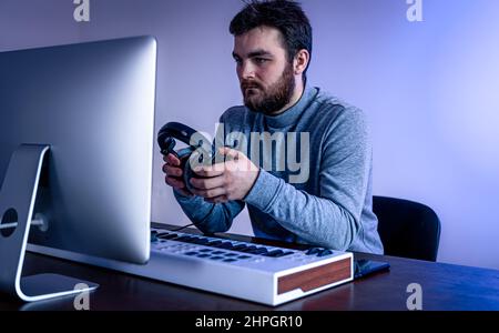 Male musician creates music using computer and keyboard, musician ...
