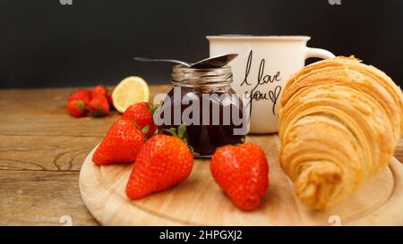 Tea break snacks. Lemon tea, croissant, jar of jam and fresh ...
