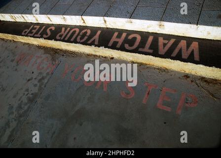 Watch your step sign on old train steps Stock Photo - Alamy
