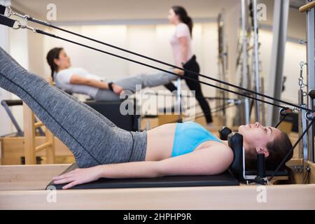 Woman exercising torson rotation at gym using pilates beds Stock Photo ...