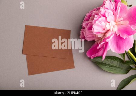 Brown business card with pink peony flowers and cup of coffee on white ...