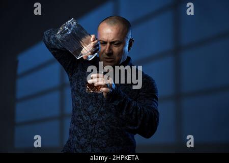 Businessman checking his empty whiskey bottle after pouring the last ...