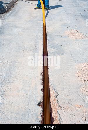 Pipe and cables in trench at road crossing laying pipelines. Building ...