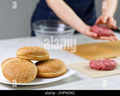 Woman's hand forming a beef meat for a hamburger party. Portioning ...