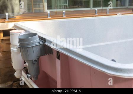 Fibreglass swimming pool in position with plastic plumbing pipework and ...