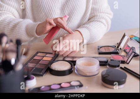 A faceless woman watches online training from a professional makeup ...