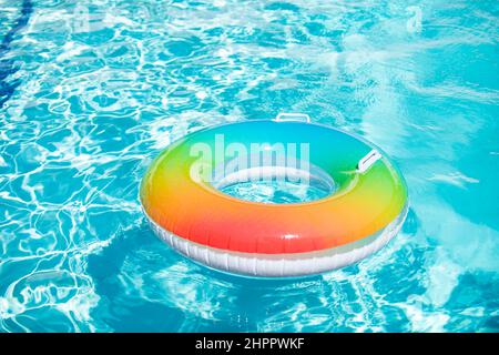 Pool float, rainbow ring floating in a refreshing blue swimming pool ...