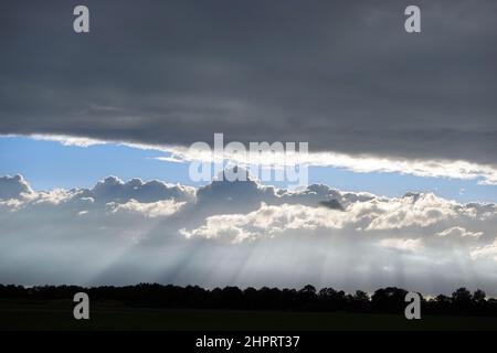 Dramatic dark clouds with bright light breaking through the overcast ...