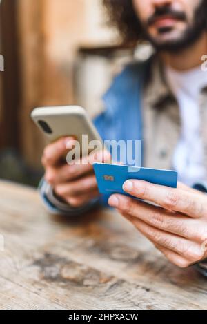 Crop anonymous male buyer in protective mask using smartphone to make ...