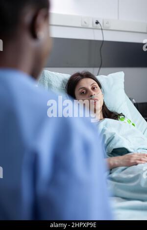 Patient with nasal cannula recieving oxygen in private ward looking at ...