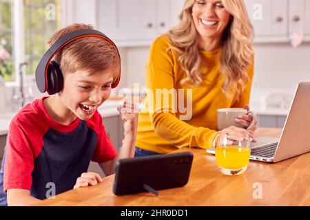 Two women gaming and streaming with laptop keyboard headset and ...