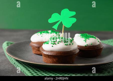 Festive chocolate cupcakes for Happy St Patricks Day on green ...