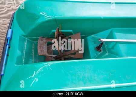 an old plastic inverted boat on the shore of the sea bay, an old ...