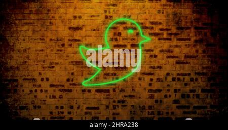 Image of glowing neon bird icon on brick wall. social media and ...