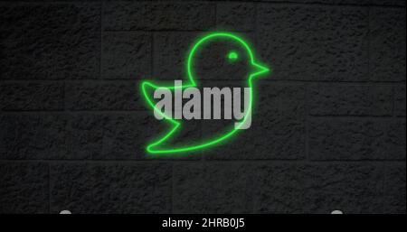 Image of glowing neon bird icon on brick wall. social media and ...