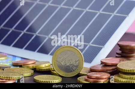 Closeup of a mini solar panel with coins Stock Photo - Alamy