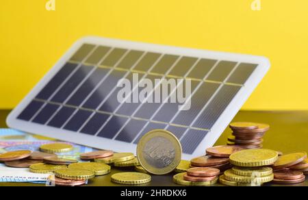 Closeup of a mini solar panel with coins Stock Photo - Alamy