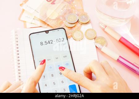 Girl calculating with smartphone and coins in the background Stock ...