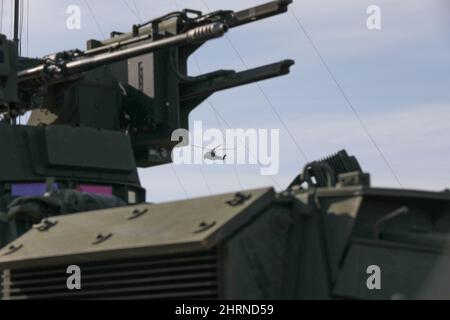 A Polish Hind flies above a U.S. Maneuver Short Range Air Defense ...